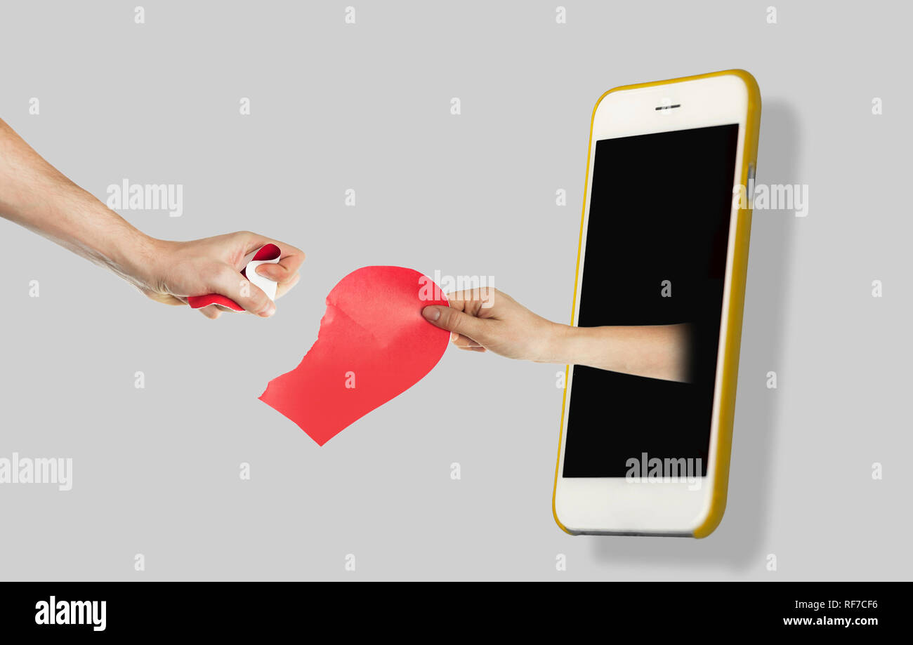 A hand holding a hand sticking out of the phone screen on an isolated ...
