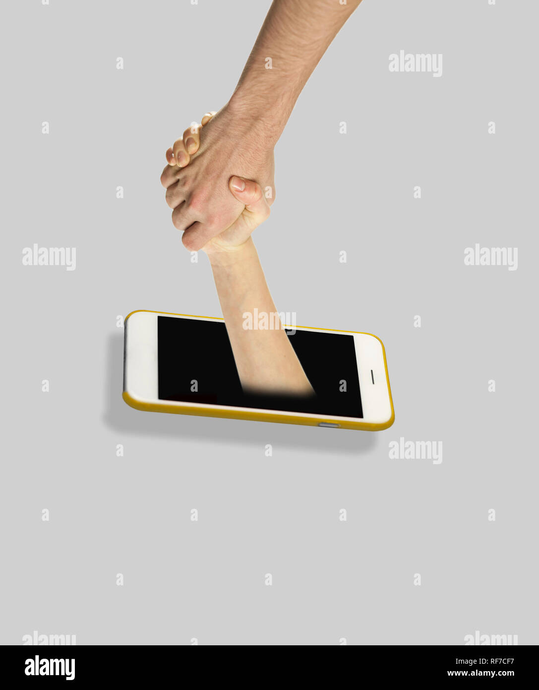 A hand holding a hand sticking out of the phone screen on an isolated ...