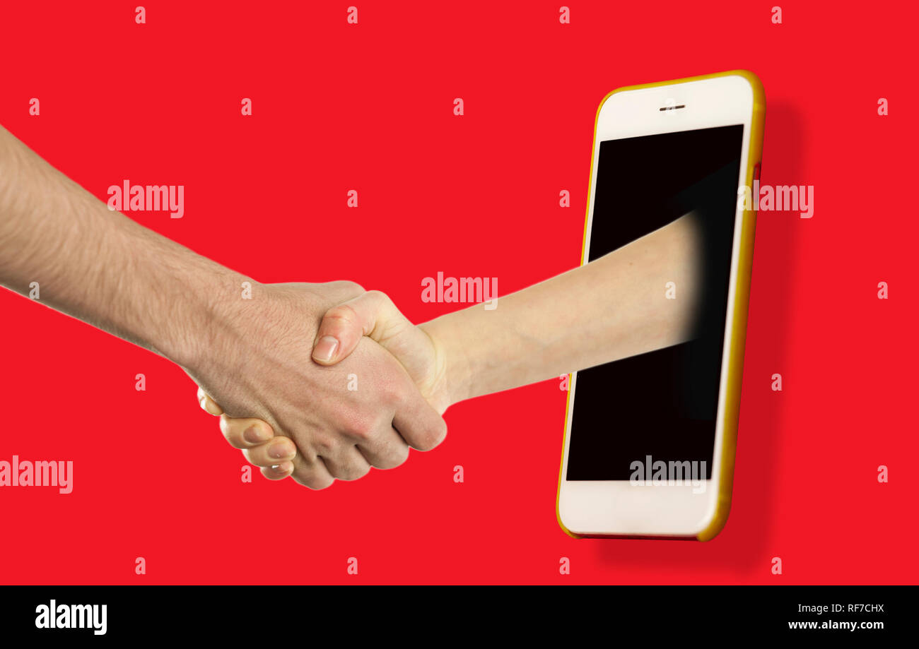 A hand holding a hand sticking out of the phone screen on an isolated ...