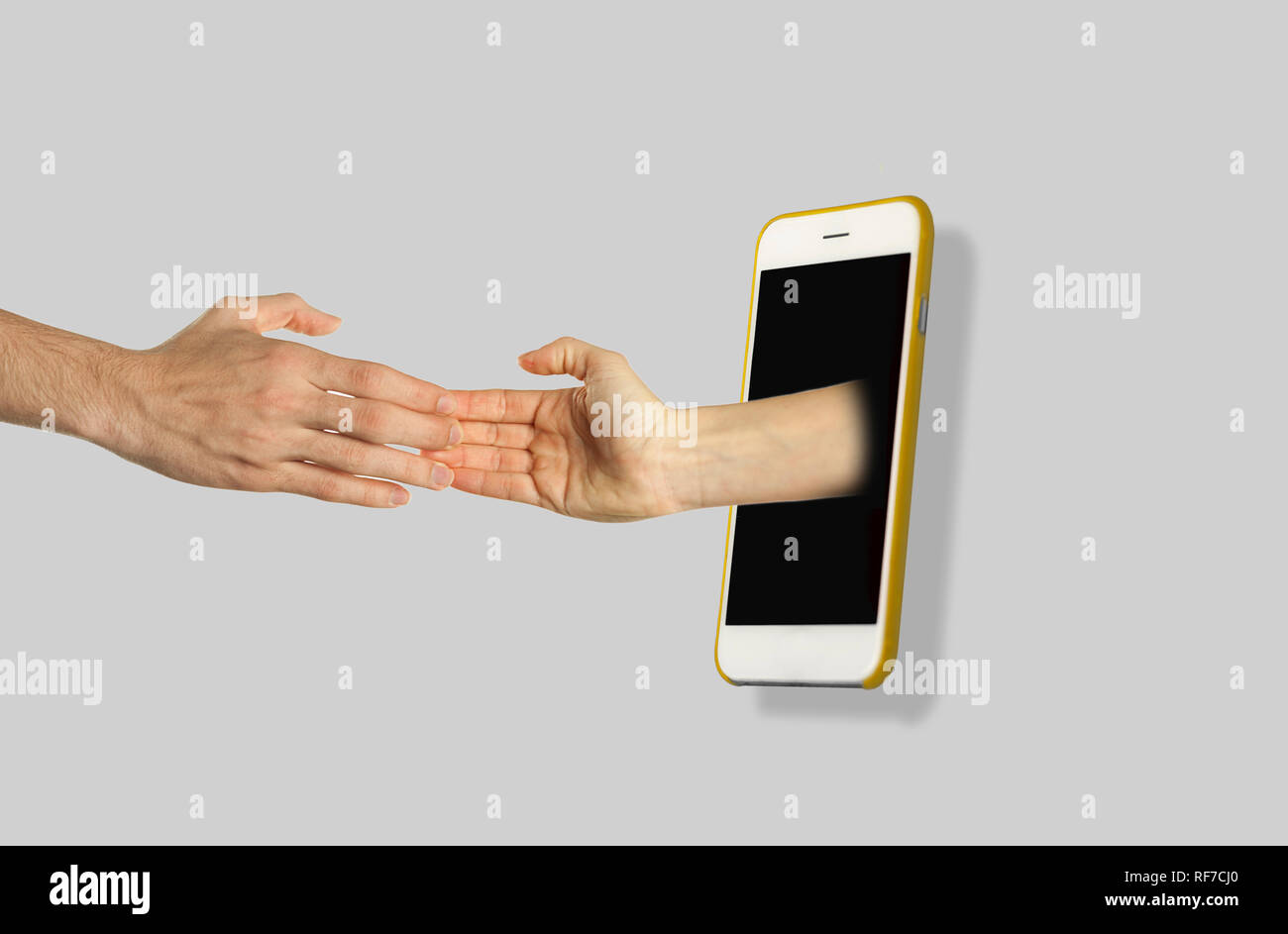 A hand holding a hand sticking out of the phone screen on an isolated ...