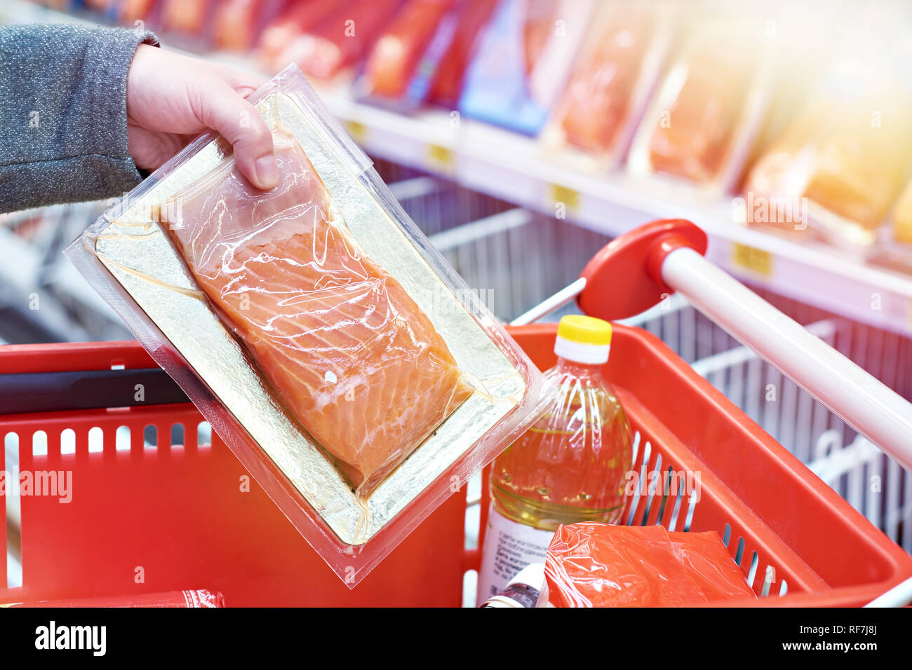 Packing of salmon fish in the hand of the buyer at the grocery store ...