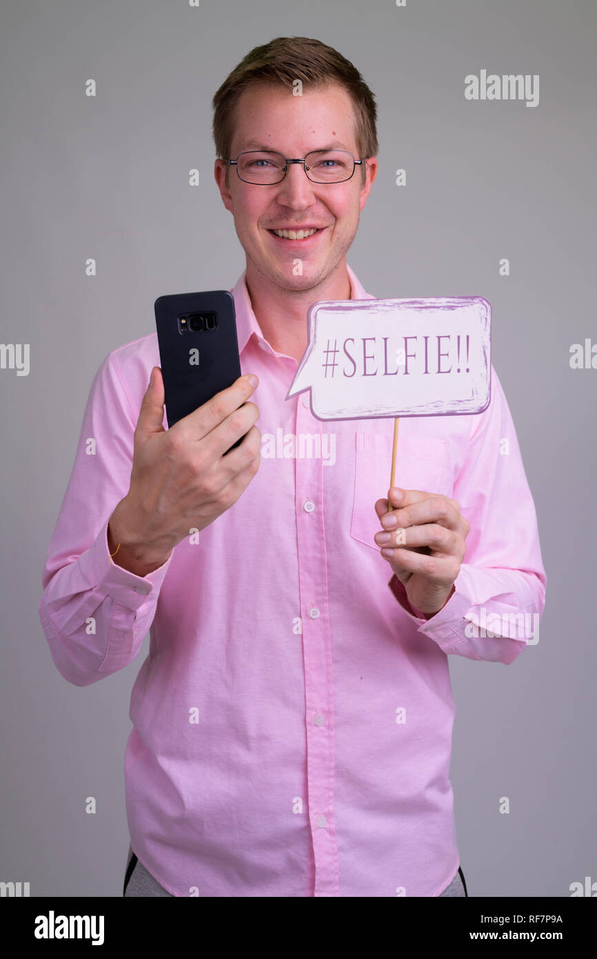 Young happy businessman holding phone with selfie paper sign Stock ...
