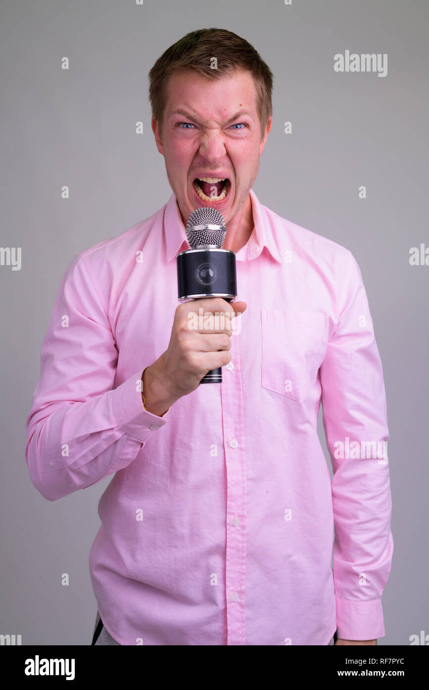 Angry young businessman as host shouting on the microphone Stock Photo ...