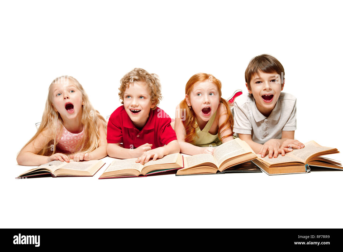 The surprised kids boy and girls laying with books at studio, smiling ...