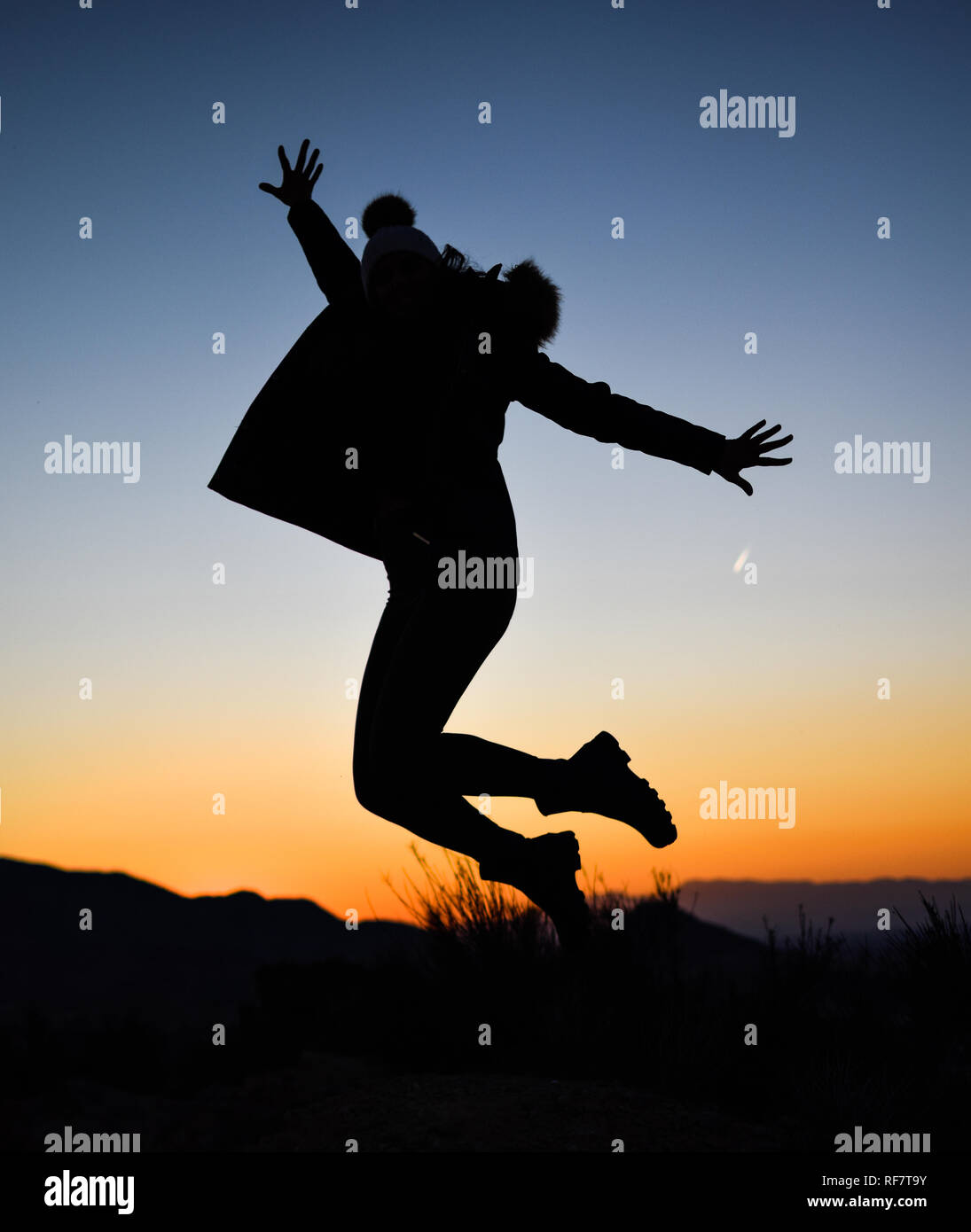 Silhouette of girl jumping against sunset Stock Photo - Alamy