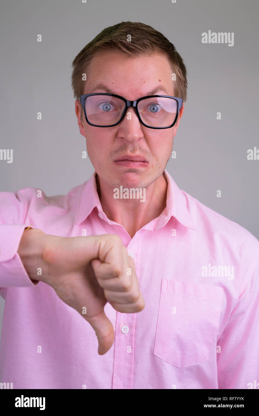 Face of angry young nerd businessman giving thumbs down Stock Photo - Alamy