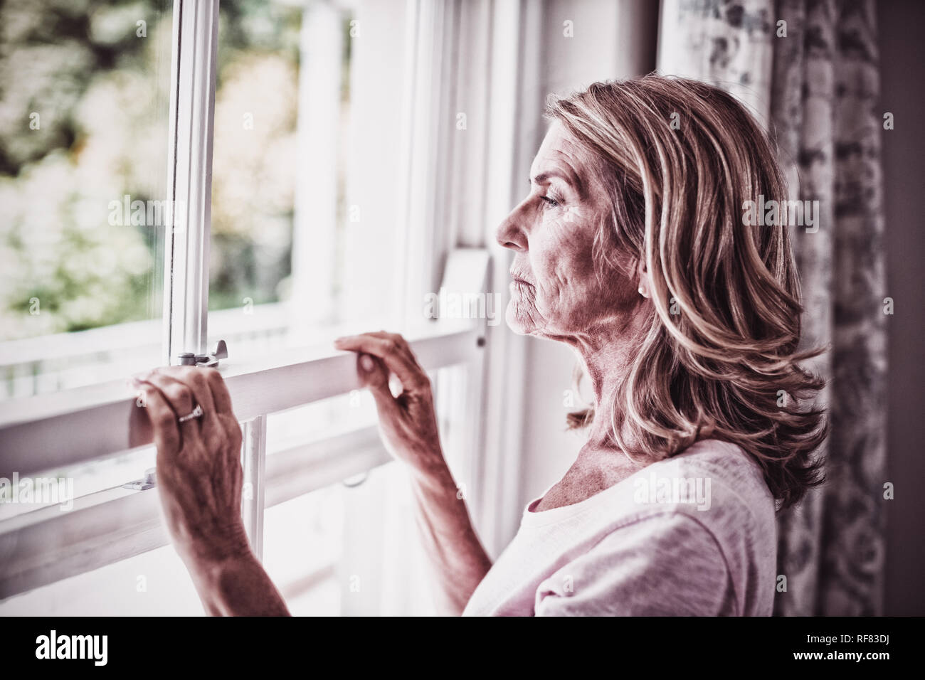 Elderly woman looking out of window hi-res stock photography and images ...
