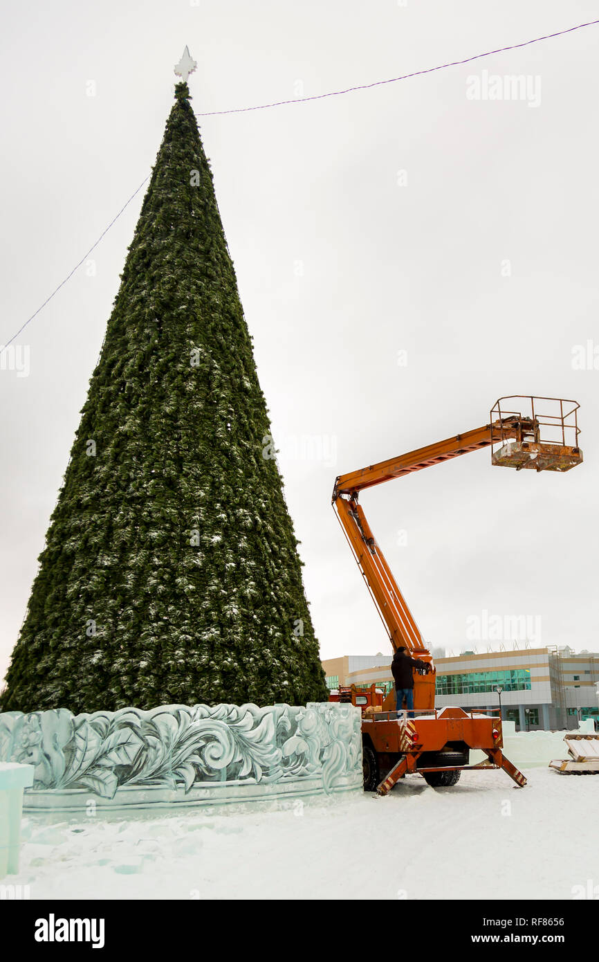 Big Christmas tree and car lift in the ice town under construction ...