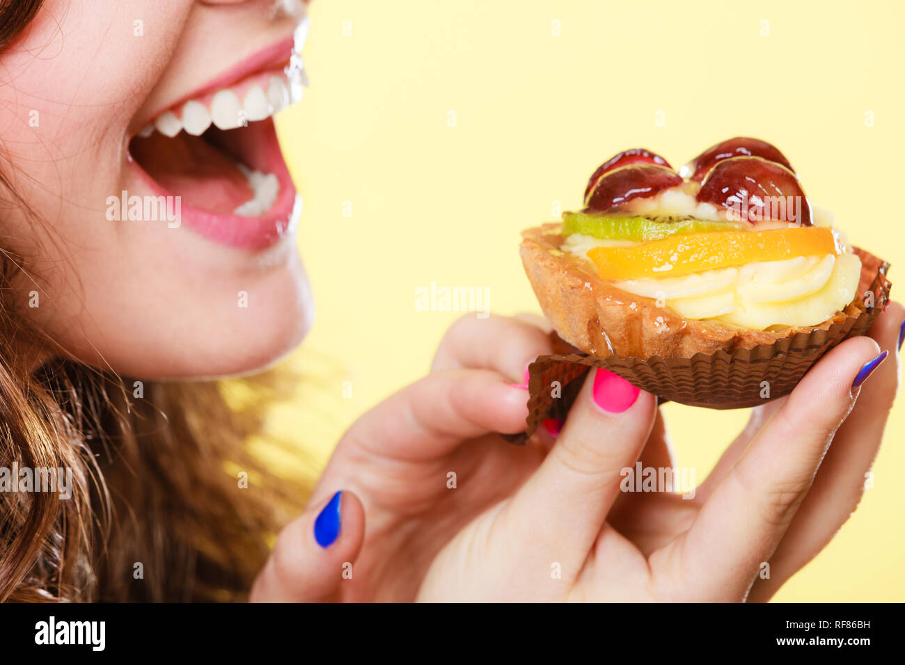 Sweetness and happiness concept. Closeup cute woman curly hair eating ...