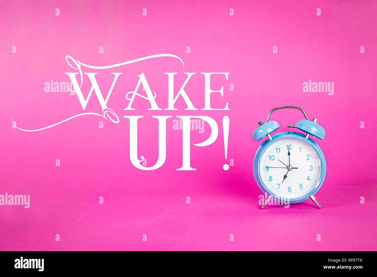 Beautiful blue pastel alarm clock on pink background with quote Wake up ...