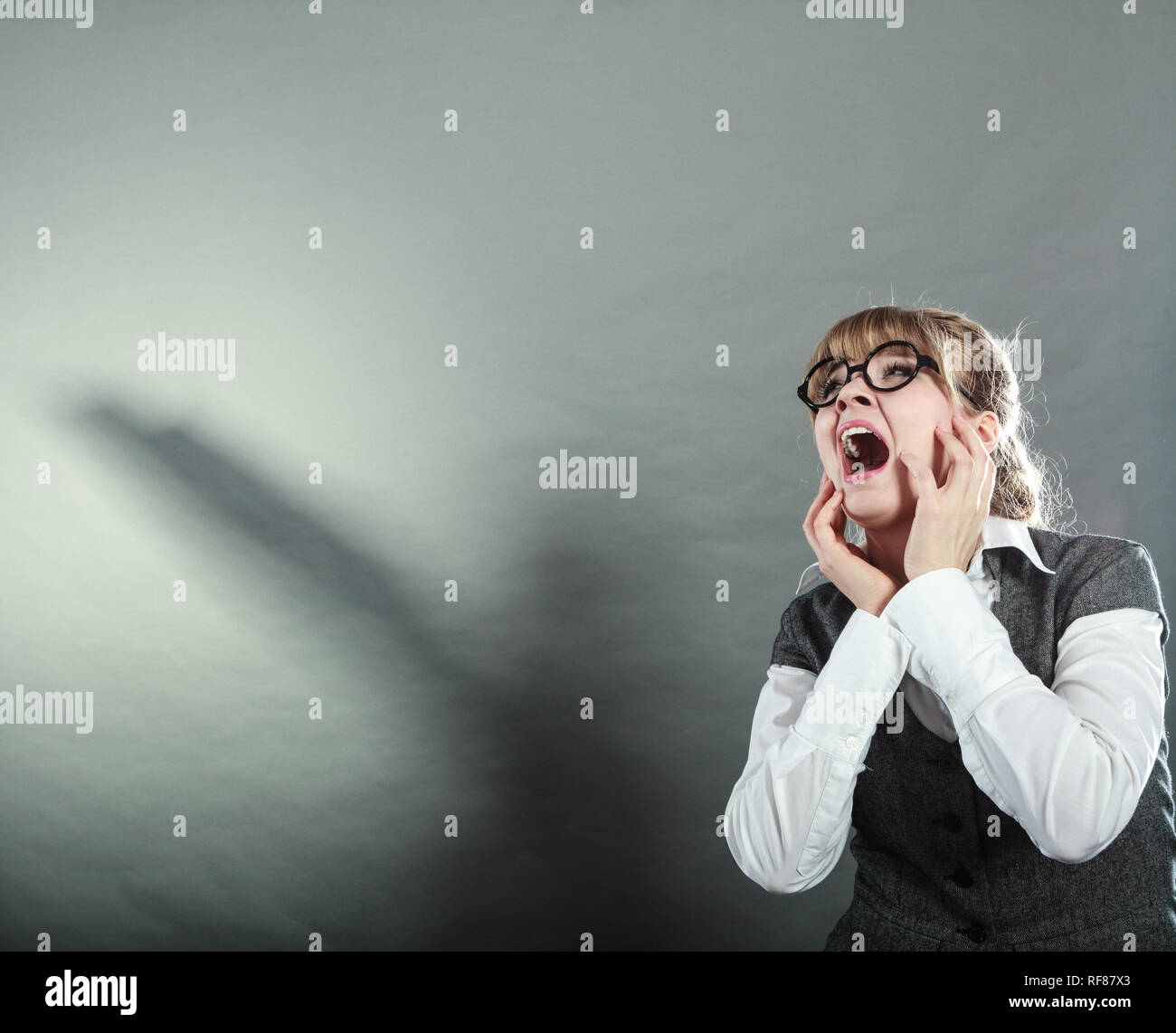 Business woman screaming looking upward in full fear wide open mouth ...