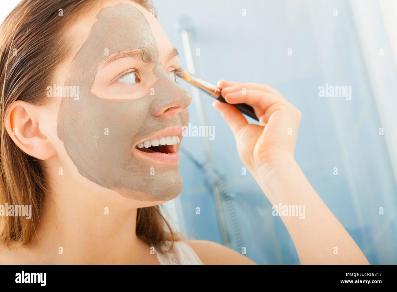 Beauty procedures skin care concept. Young woman applying facial gray ...