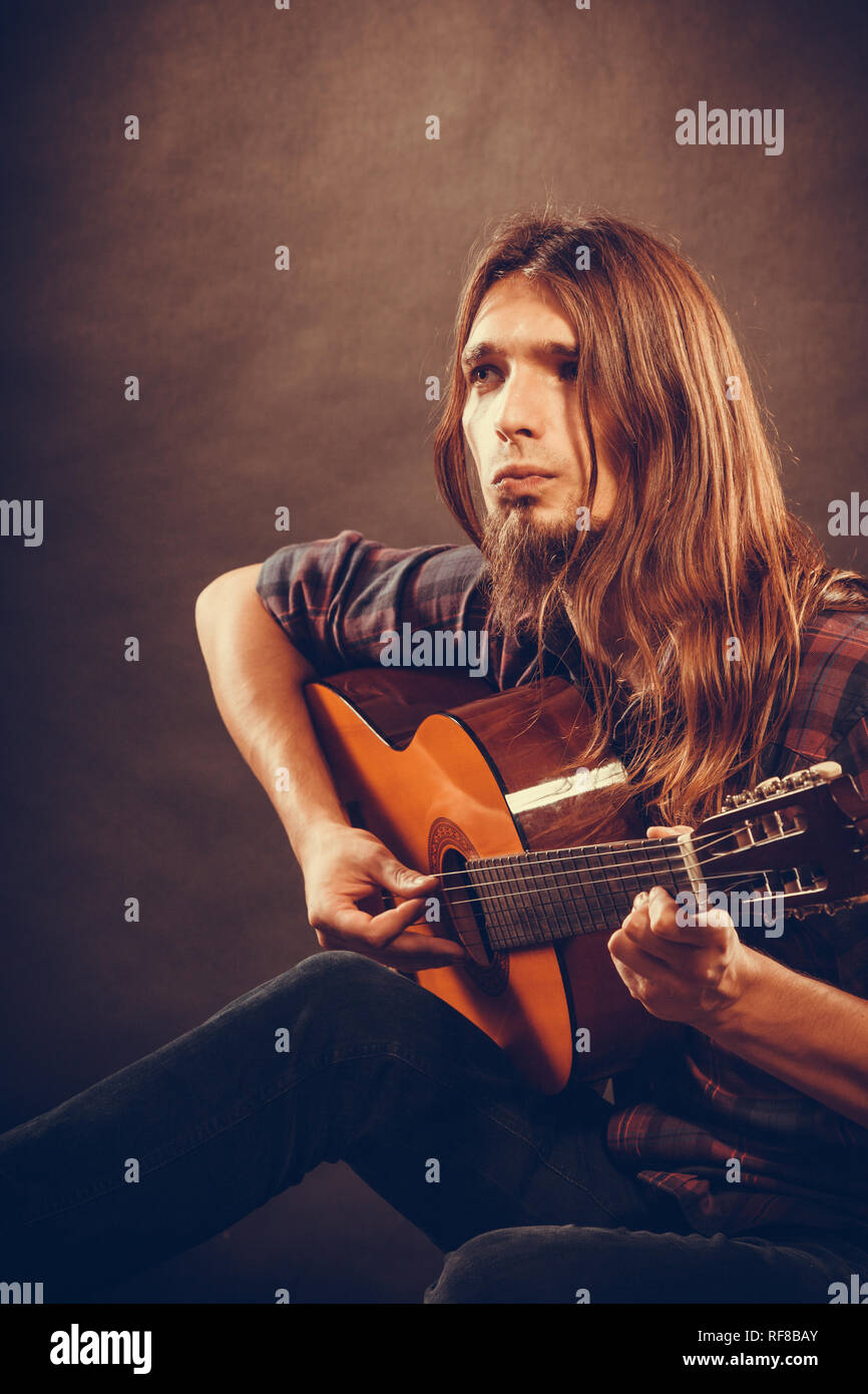 Music, hobby concept. Young man is thinking about new song. Playing the ...