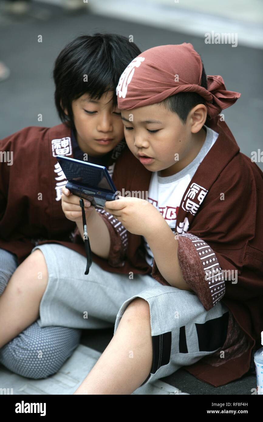 Japan, Tokyo: Shrine festival, called Matsuri. Kids playing with a ...
