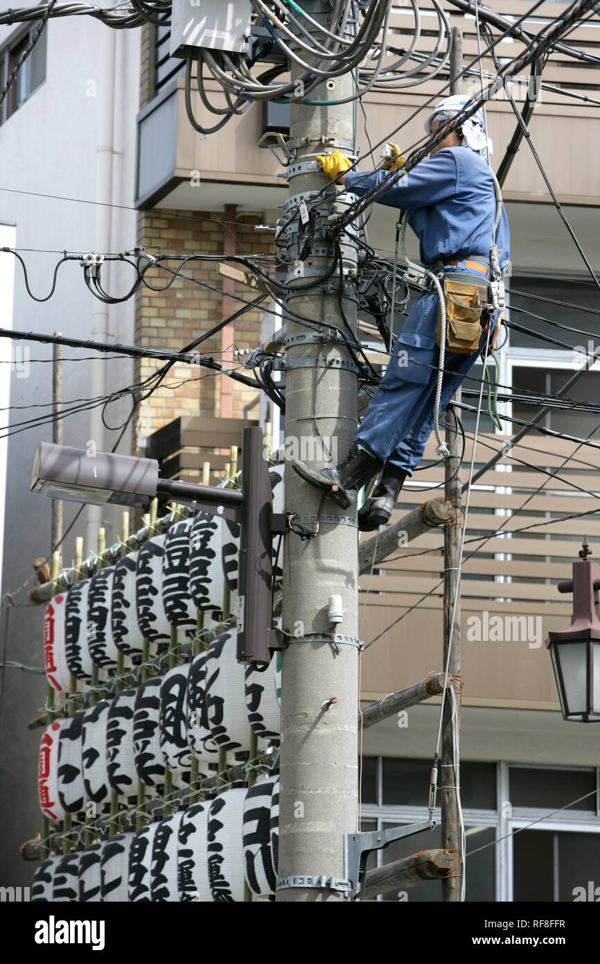 Japan, Tokyo: Worker on an electrical pole in Asakusa Stock Photo - Alamy