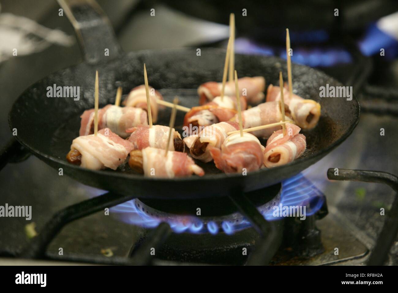 Dates rolled in bacon strips, appetizer dish at a restaurant in Germany ...