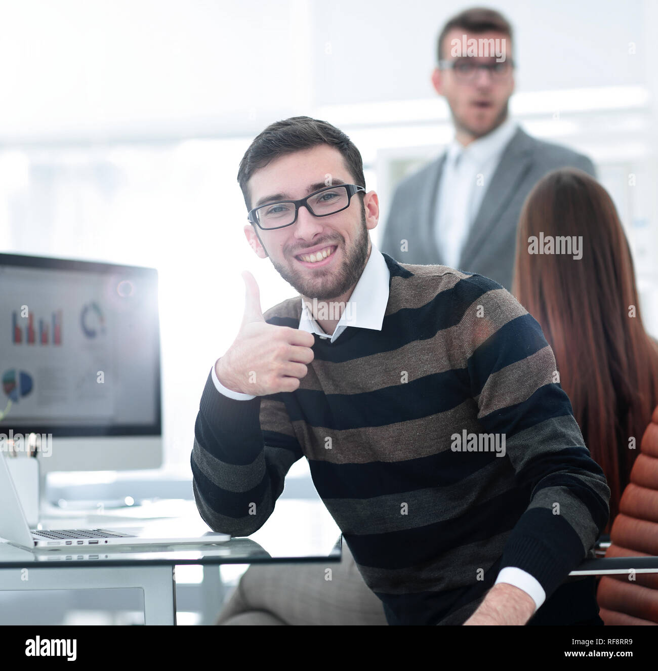 smiling employee sitting behind a Desk Stock Photo - Alamy