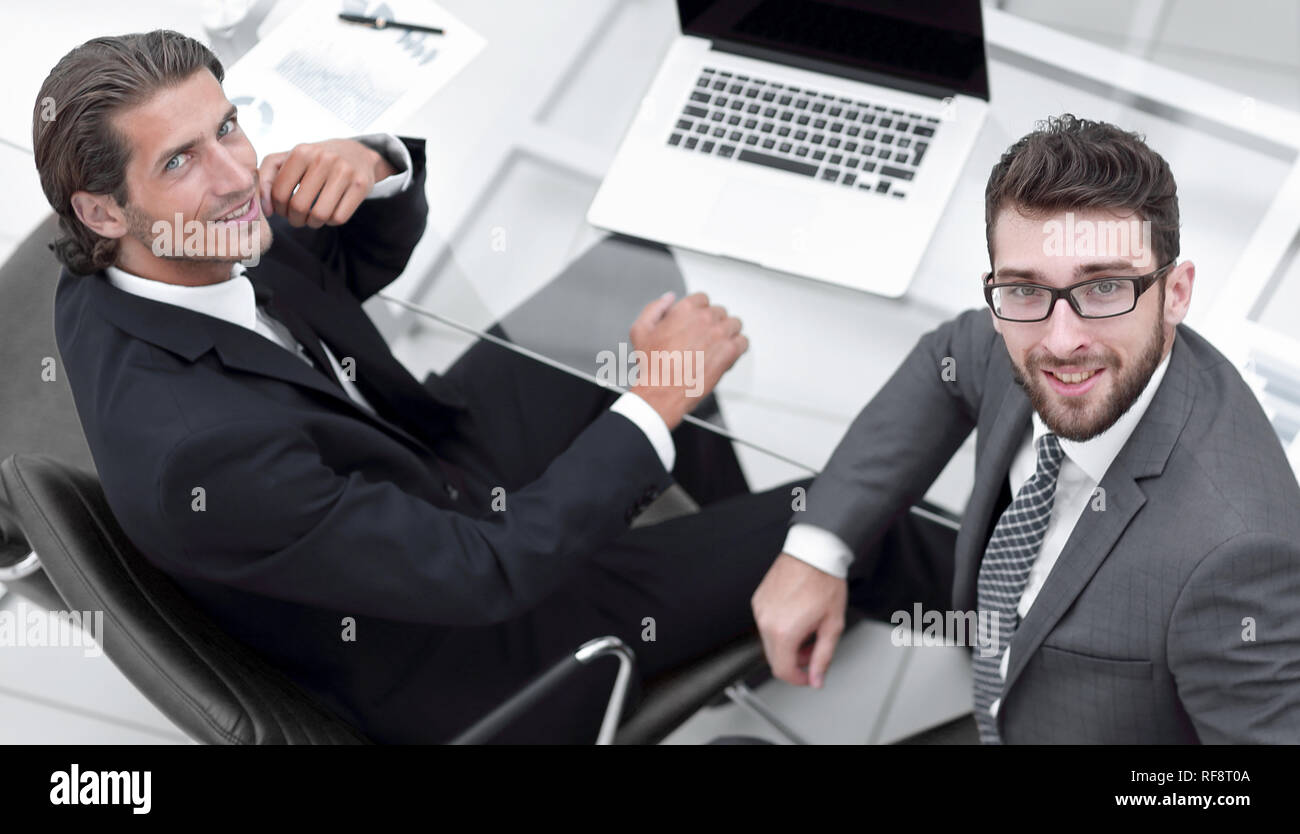 successful employees sitting behind a Desk Stock Photo - Alamy