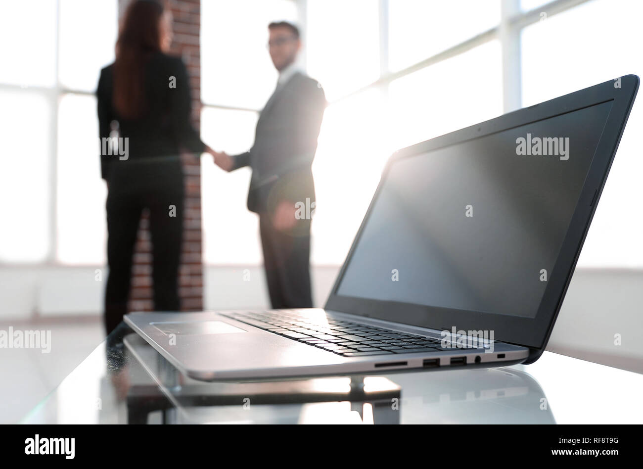 laptop on the desk, background handshake Stock Photo - Alamy