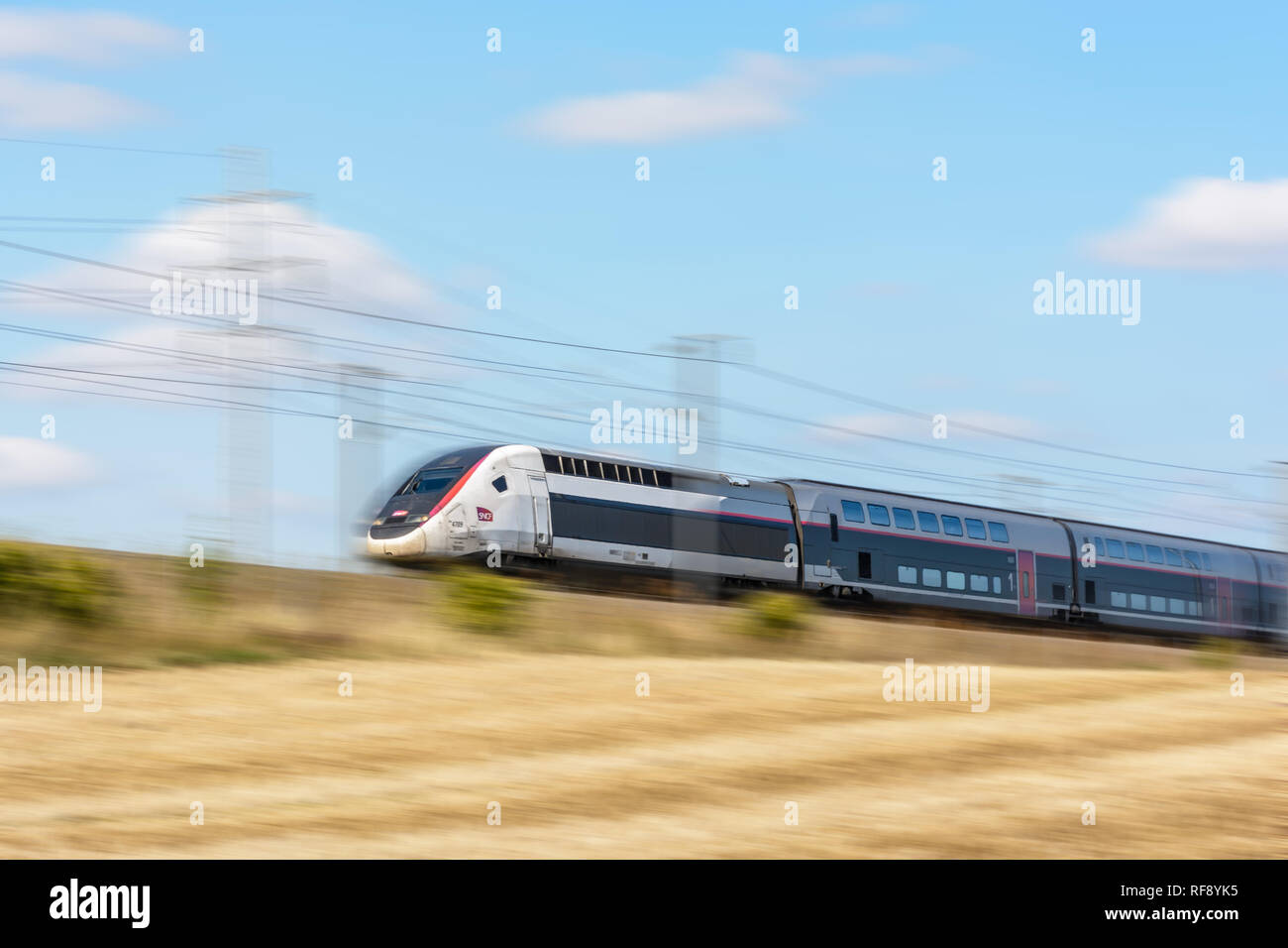 A TGV Duplex high-speed train in Carmillon livery from french company SNCF driving at full speed ...