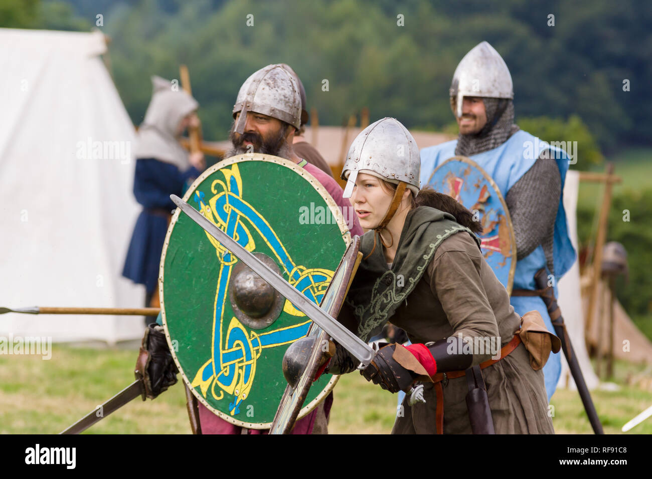 Medieval re-enactors dressed in armour and costumes of the 12th century ...