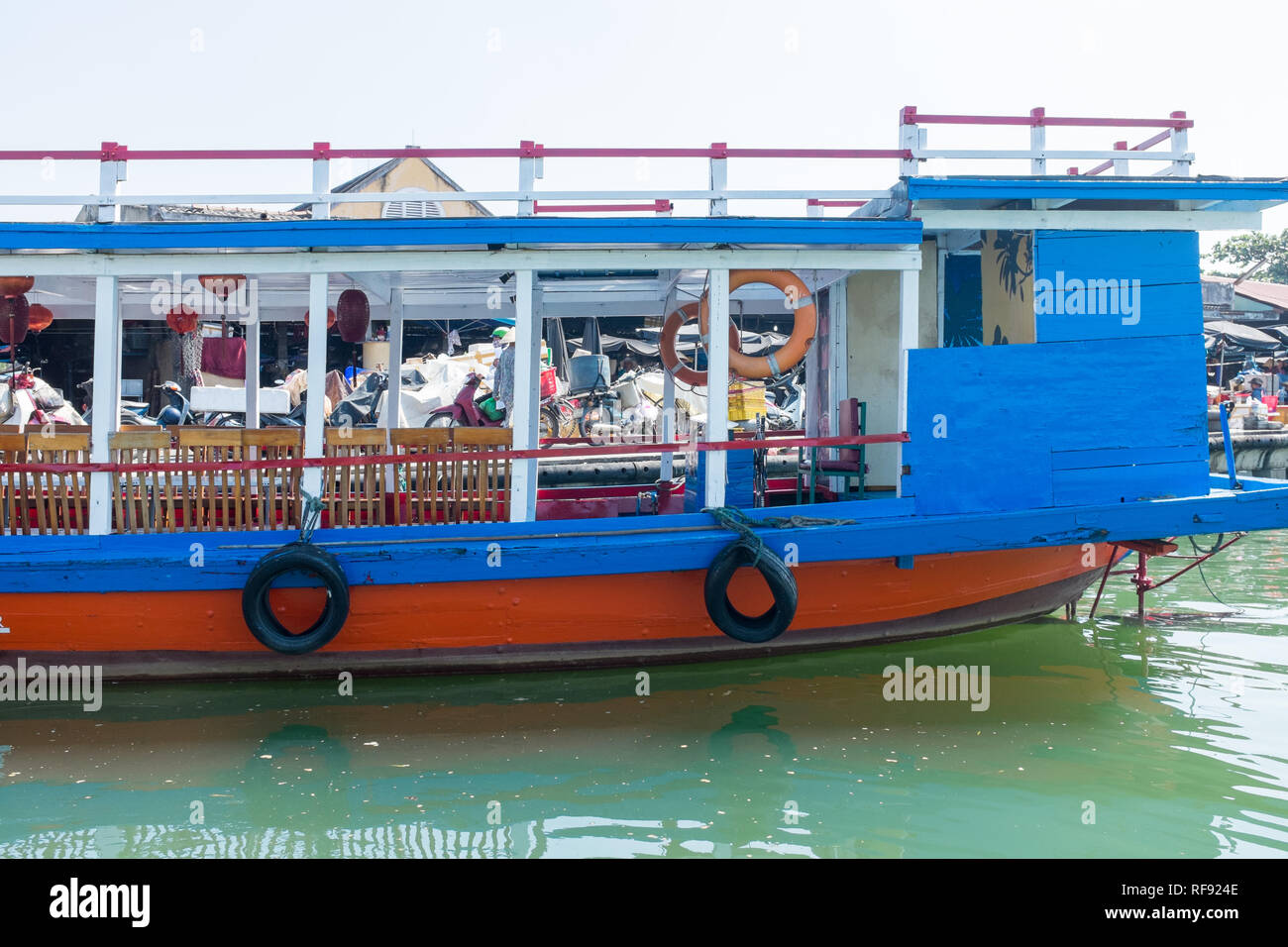 Blue and red tourist ferry on the Thu Bon River in Hoi An, Vietnam ...