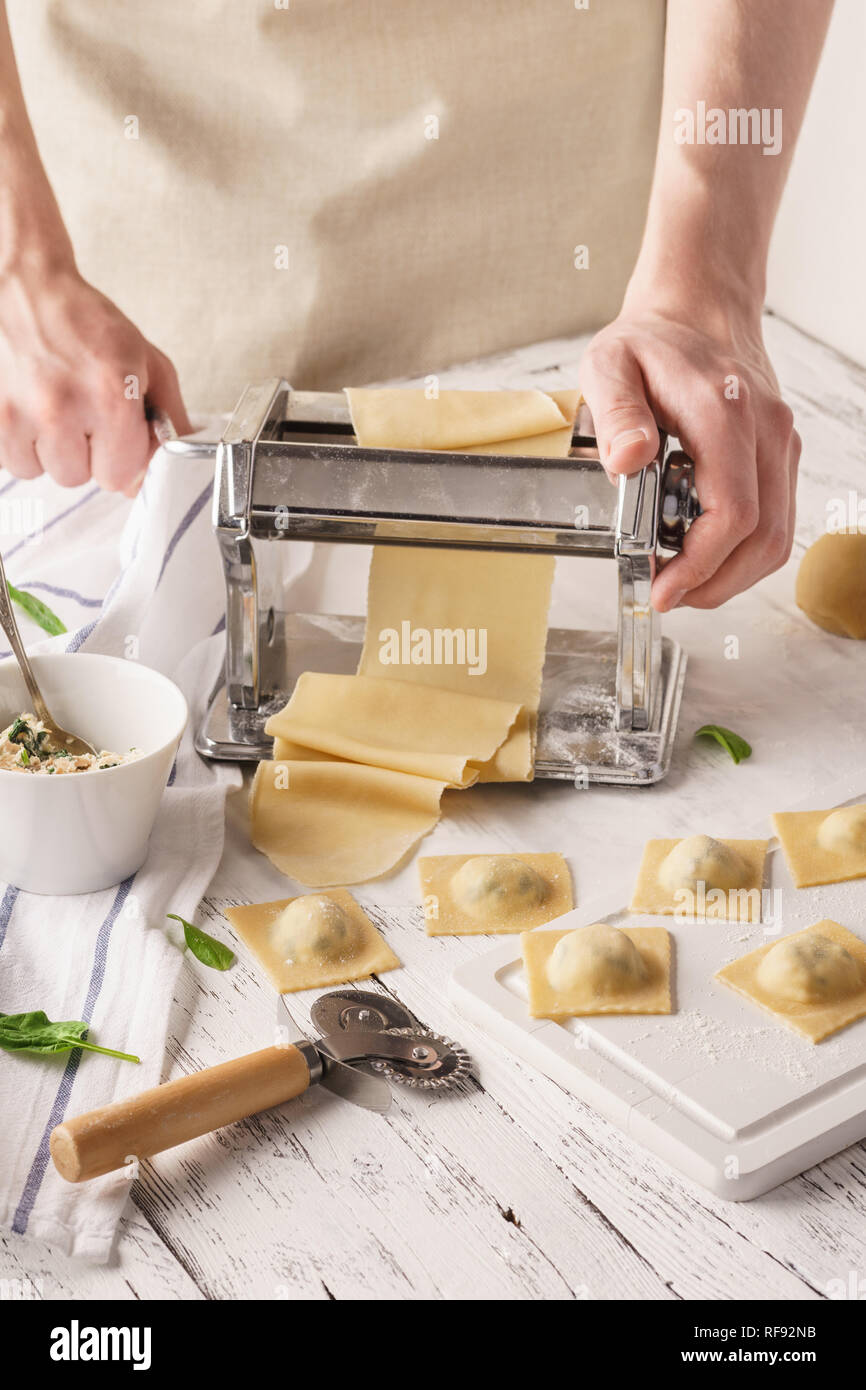 Male chef making ravioli with pasta machine. Cooking process Stock ...