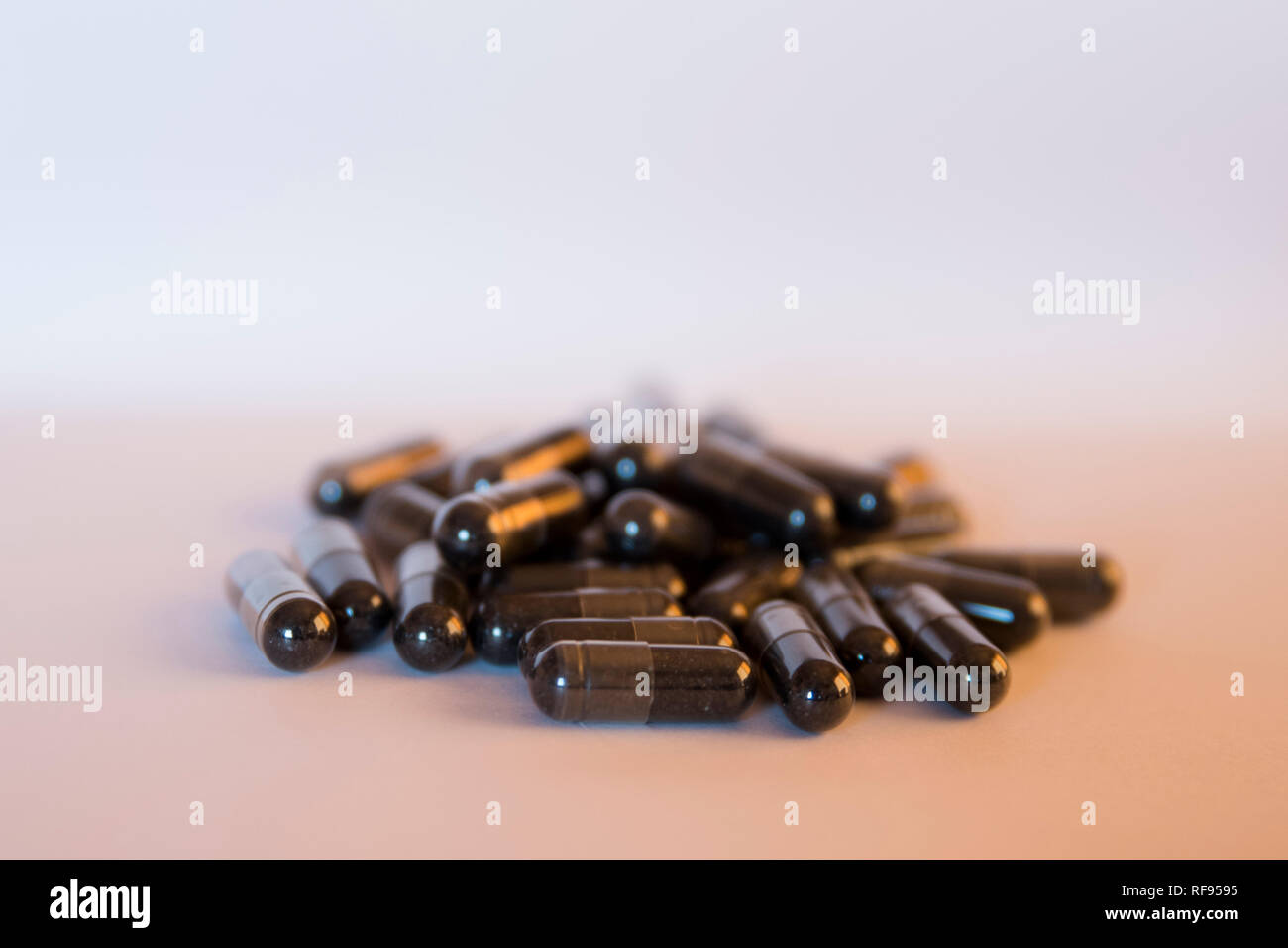 Spread out black capsules Stock Photo - Alamy