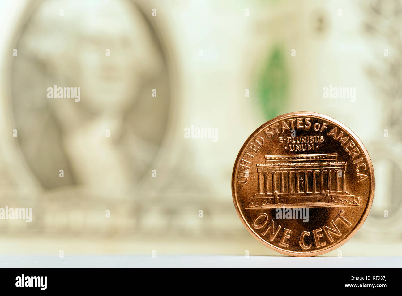 Close up of one cent coin with one American dollar note on the ...