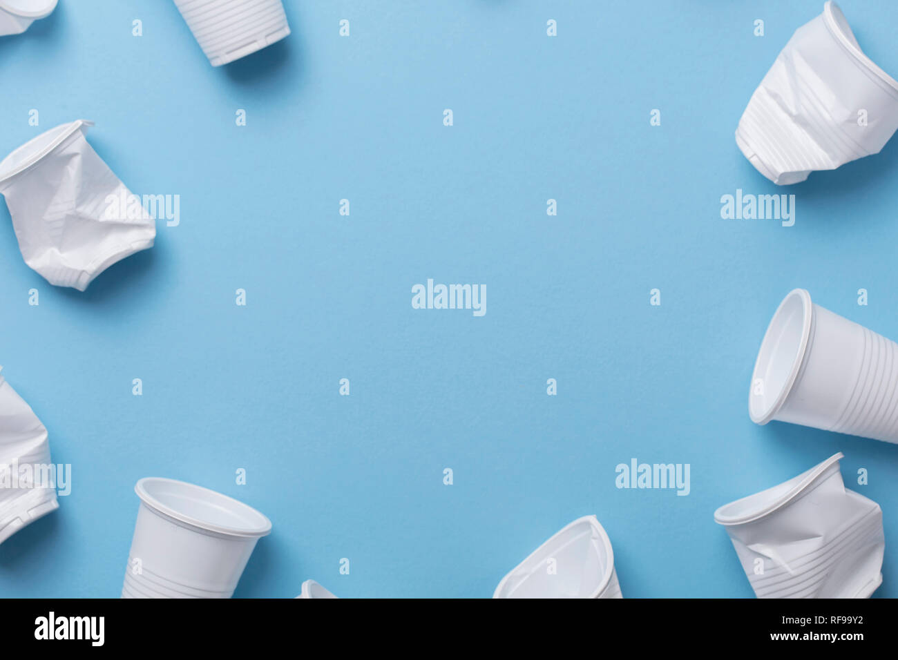 Single use white plastic cups on a blue background Stock Photo - Alamy