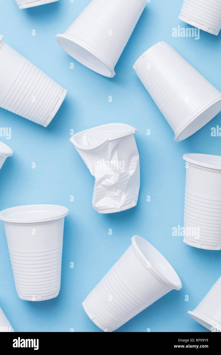 Single use white plastic cups on a blue background Stock Photo - Alamy