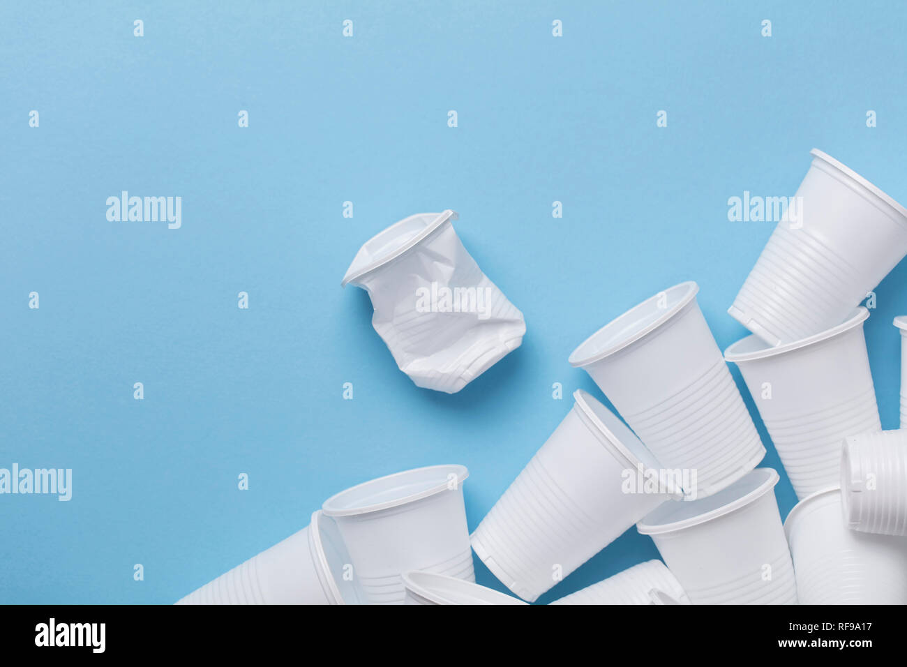 Single use white plastic cups on a blue background Stock Photo - Alamy