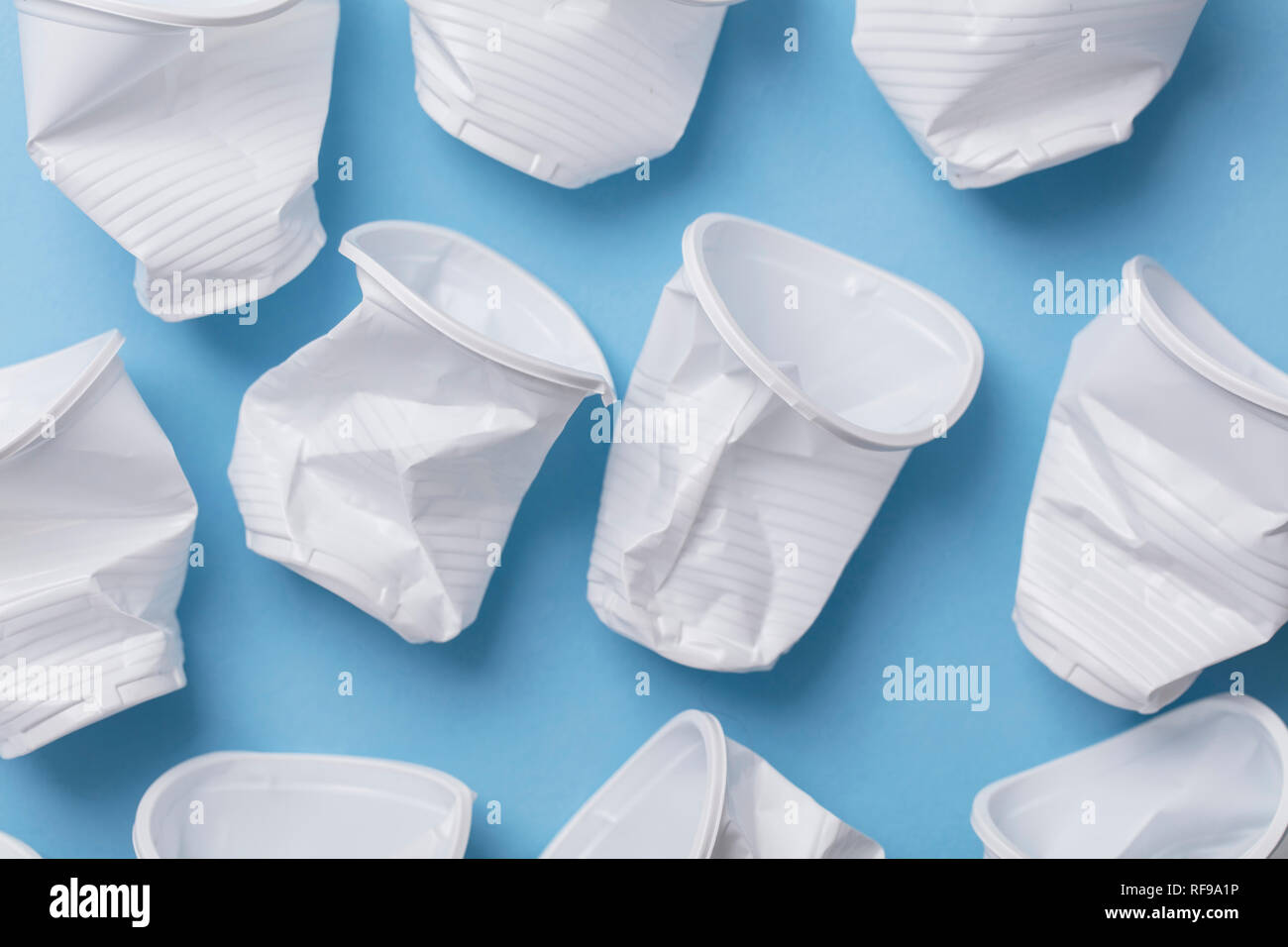 Single use white plastic cups on a blue background Stock Photo - Alamy