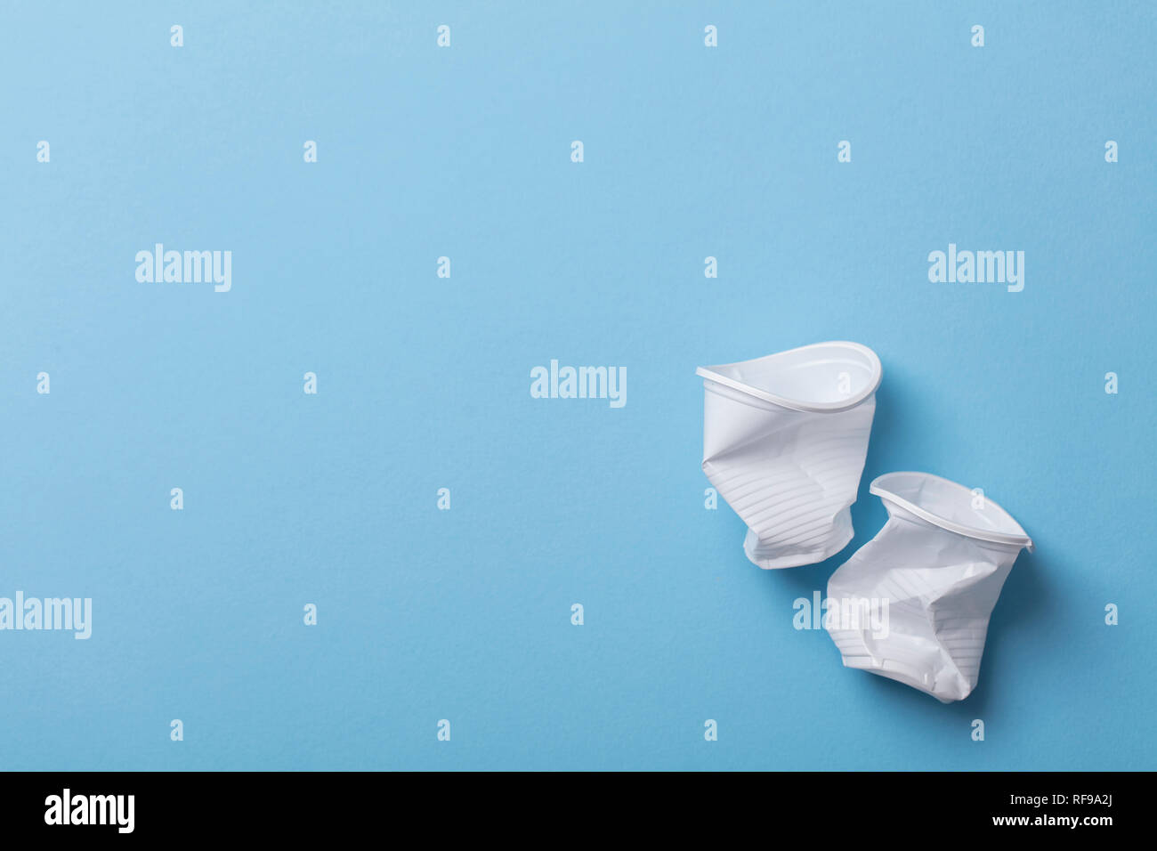 Single use white plastic cups on a blue background Stock Photo - Alamy