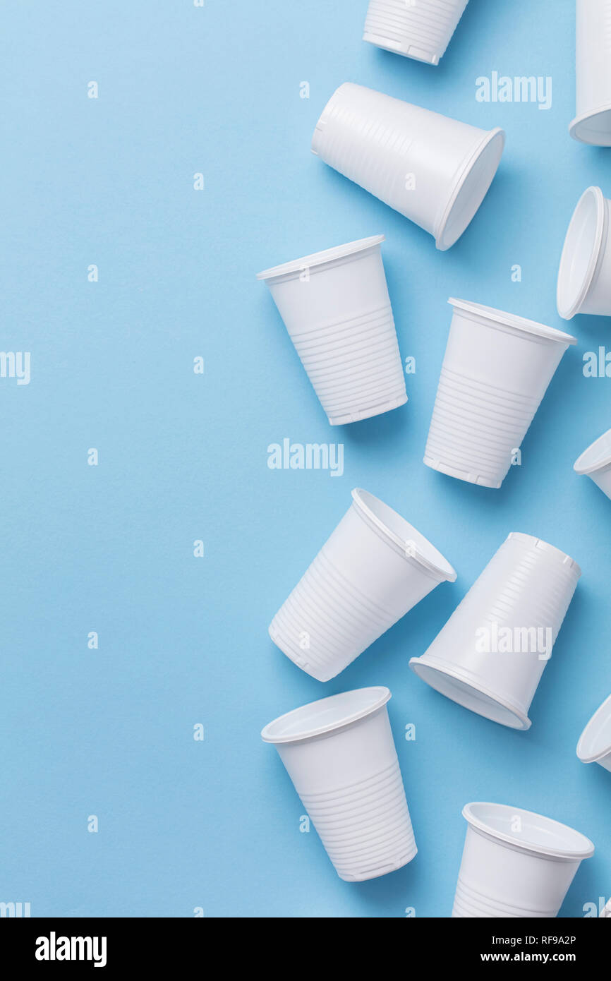 Single use white plastic cups on a blue background Stock Photo - Alamy