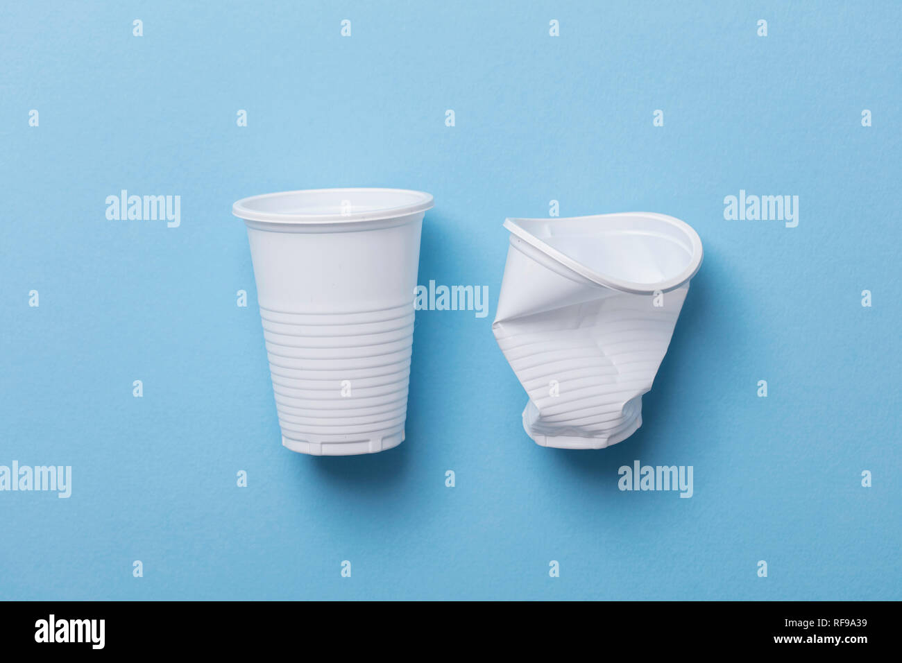 Single use white plastic cups on a blue background Stock Photo - Alamy
