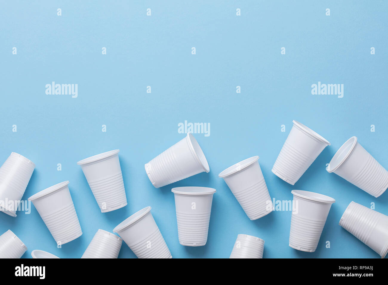 Single use white plastic cups on a blue background Stock Photo - Alamy