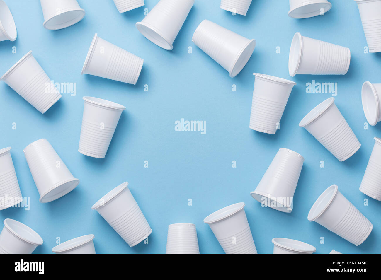 Single use white plastic cups on a blue background Stock Photo - Alamy
