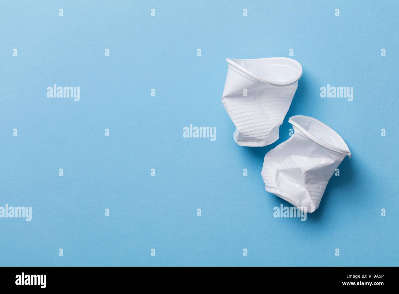 Single use white plastic cups on a blue background Stock Photo - Alamy