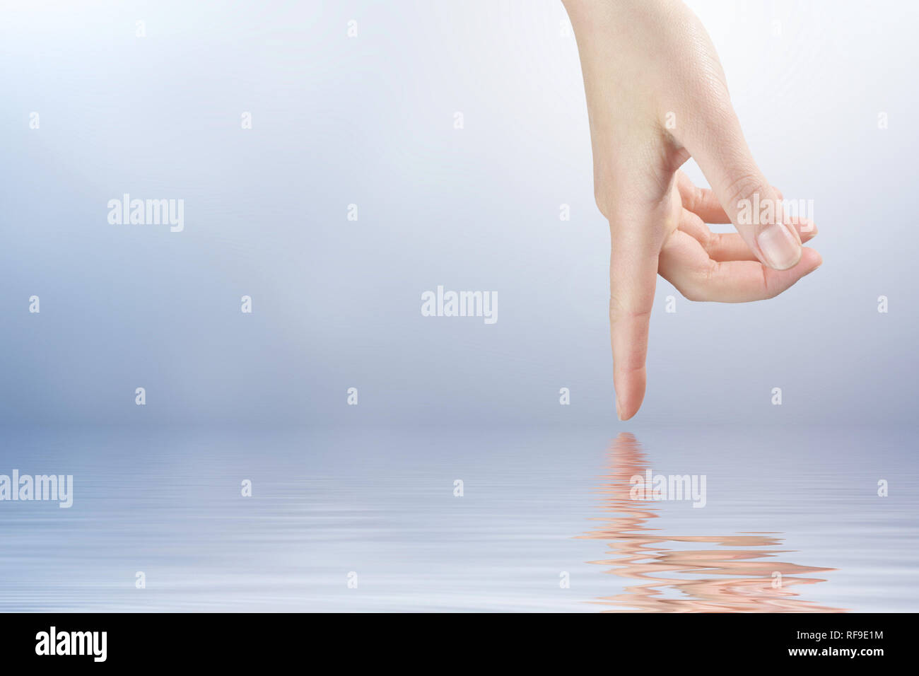 Female finger touching the water surface level Stock Photo - Alamy
