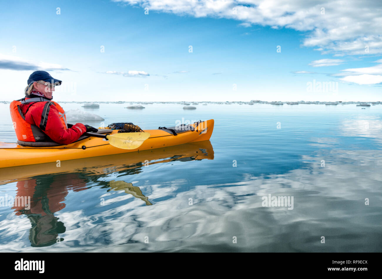 SVALBARD, Norway — A kayaker paddles through the calm, icy waters of ...