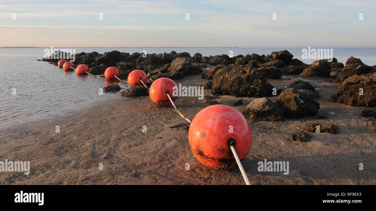 Low tide left the jetty marker buoys high and dry Stock Photo - Alamy