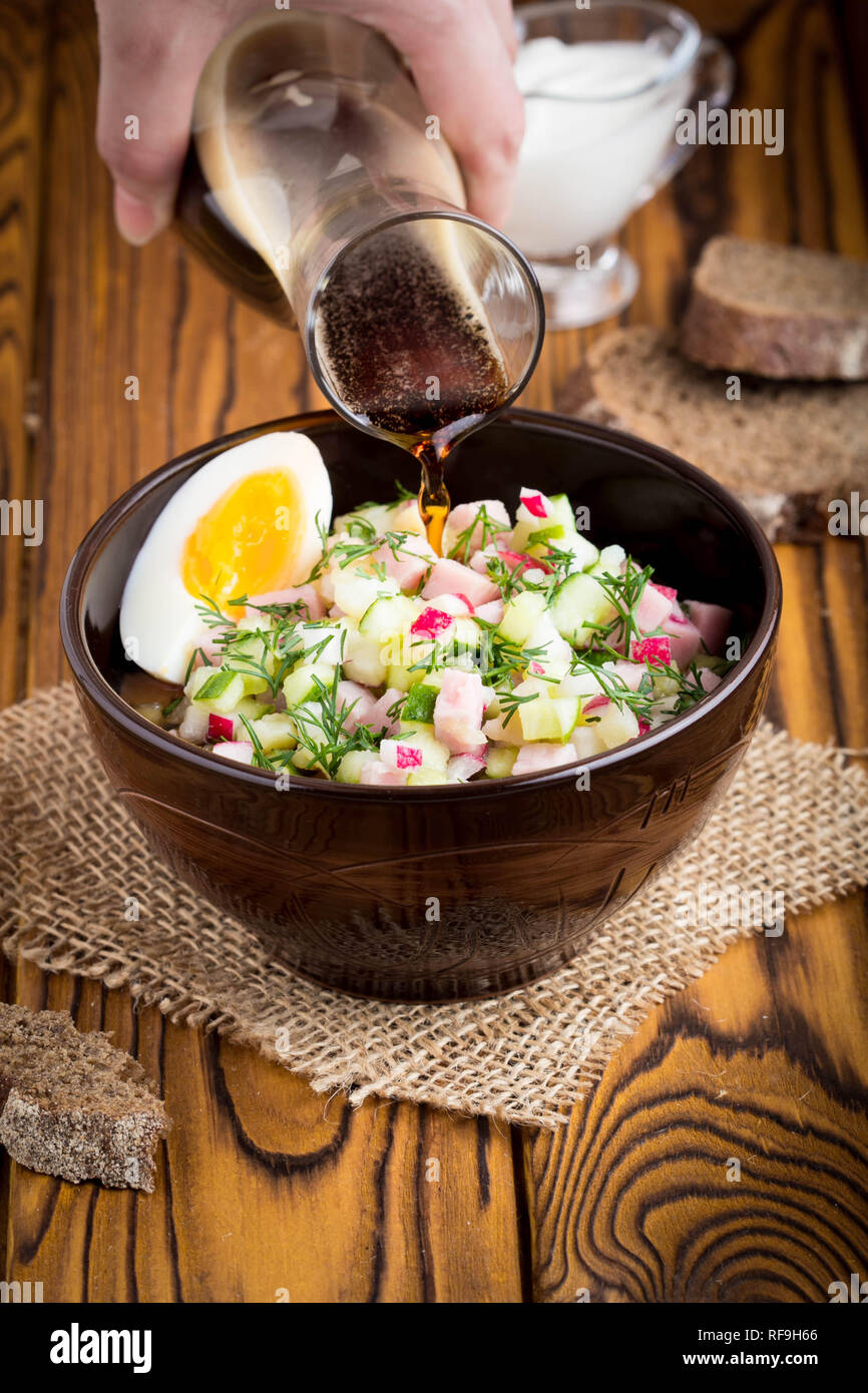 Traditional summer Russian cold soup with kvass, okroshka with ham and ...