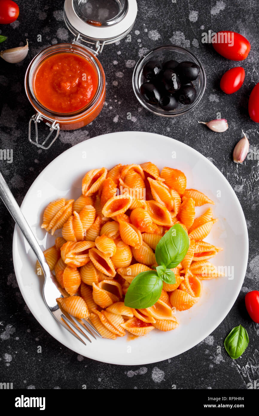 Italian shell pasta with tomato sauce, olives and Basil, classic food ...
