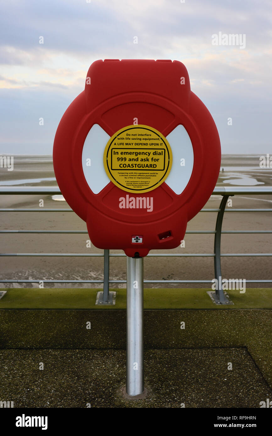 lifebuoy station on promenade with beach in background at low tide in ...