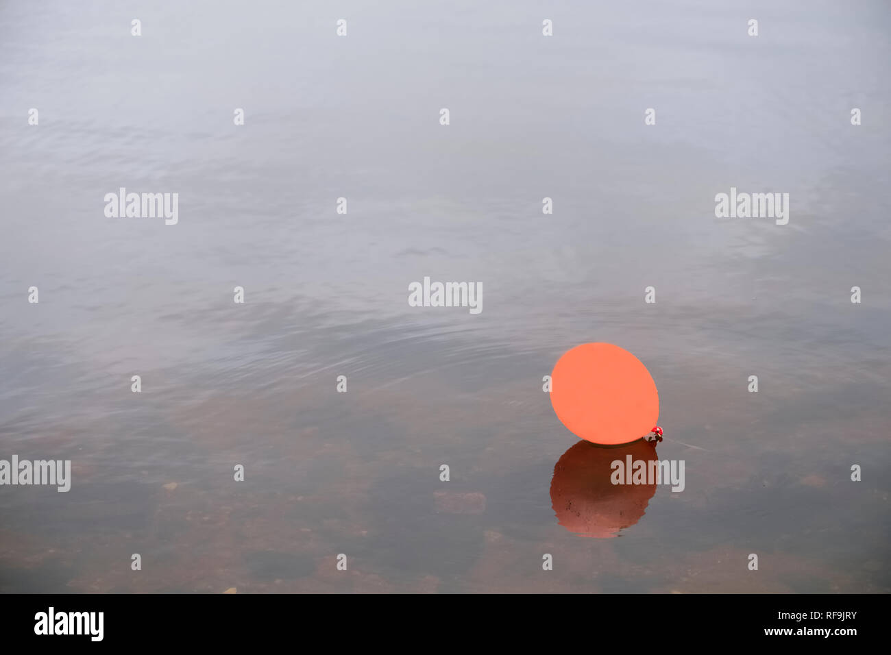 Single one red ballon floating on water Stock Photo - Alamy