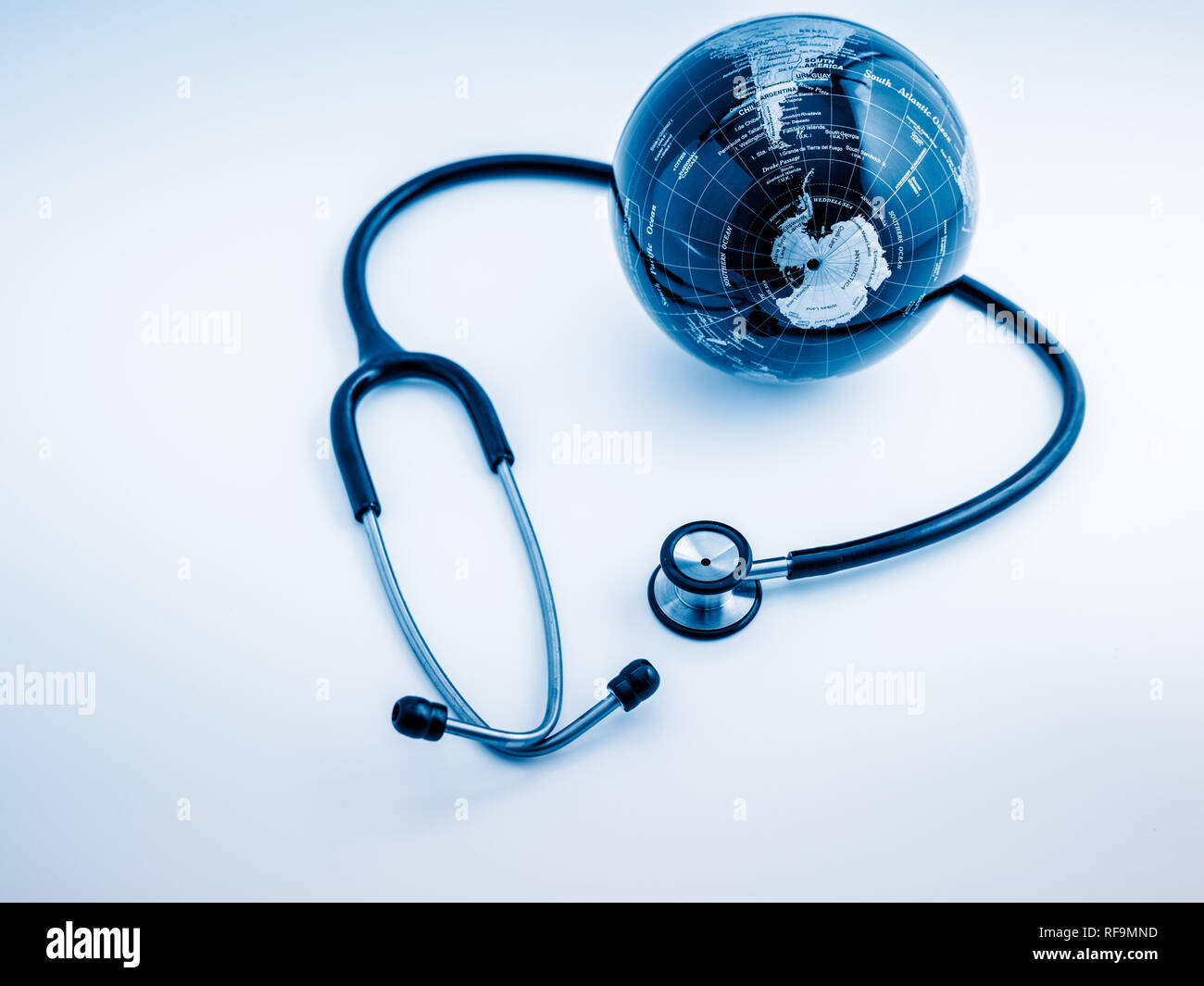 Global healthcare. Globe and stethoscope, studio shot.blue toned images ...
