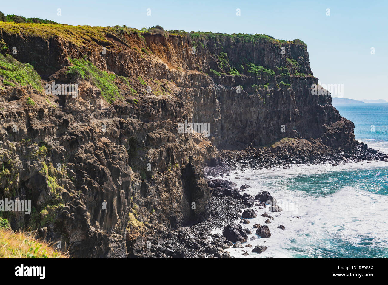 Colorful cliff face against a sunny blue ocean Stock Photo - Alamy