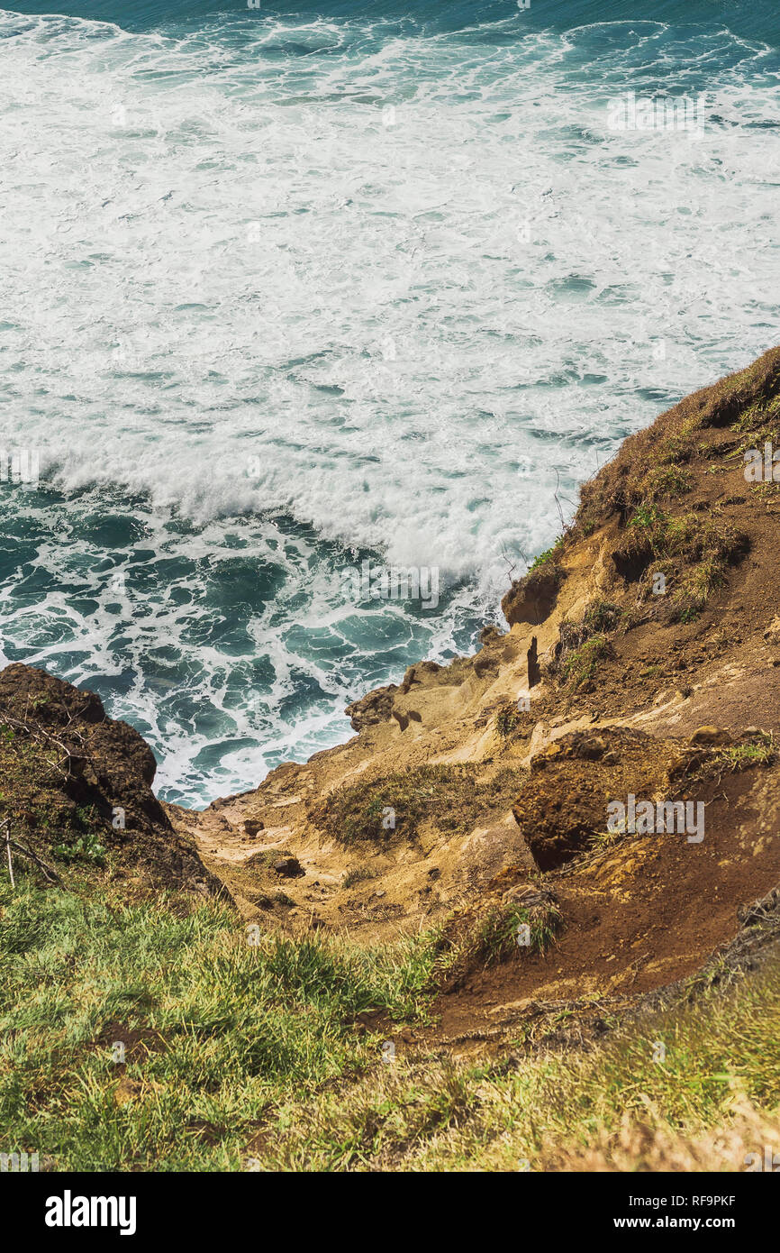 Waves crash below grassy cliff edge in Australia Stock Photo - Alamy