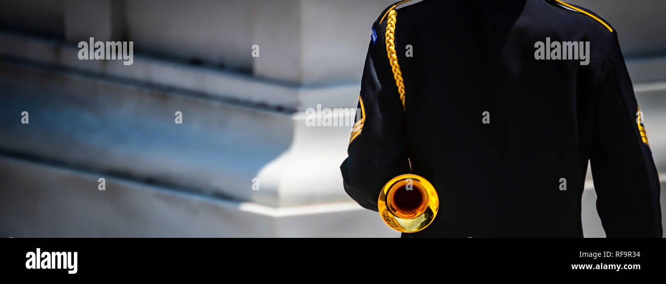 A US Army bugler stands at attention and ready to sound taps at a ...